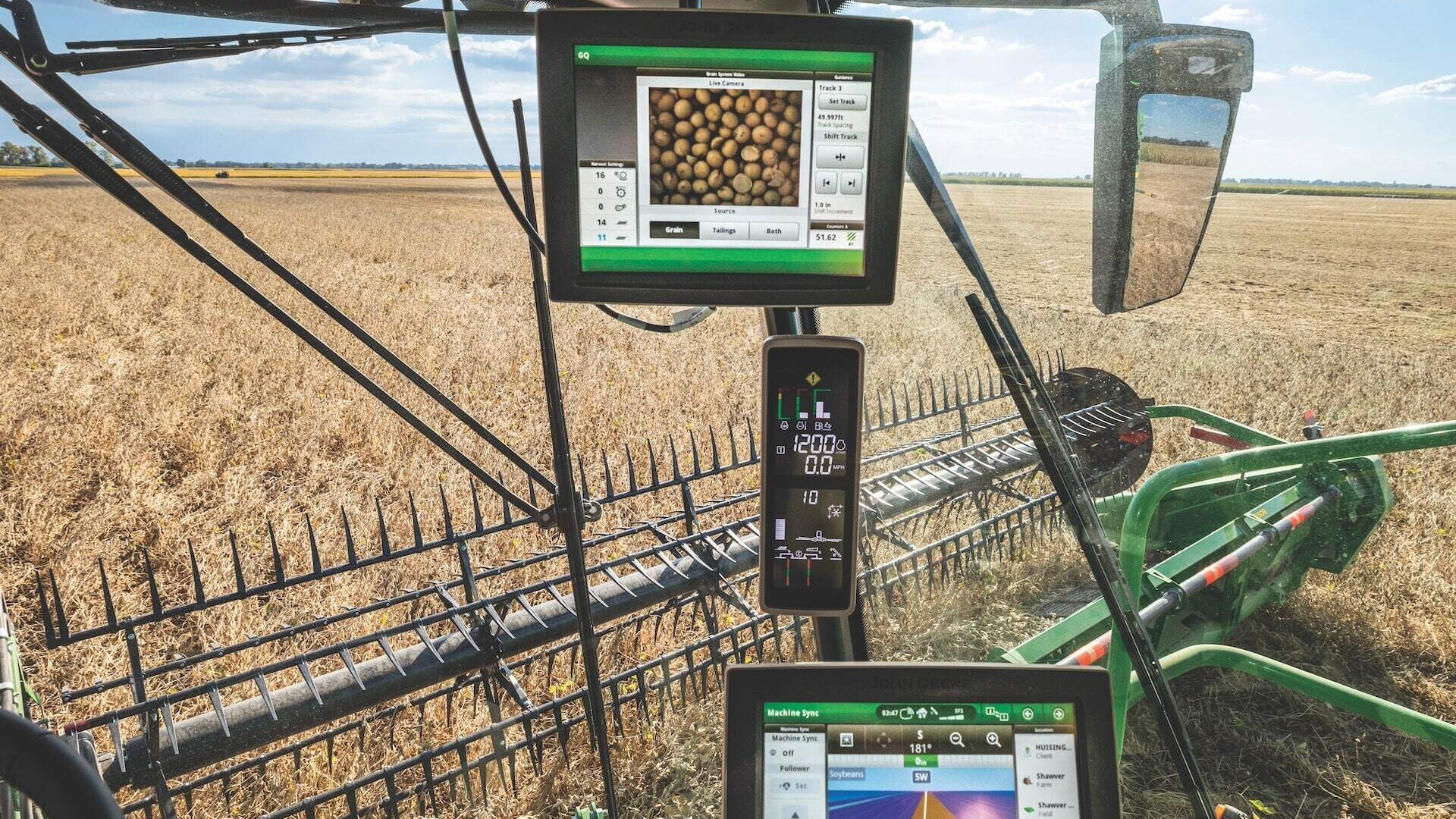 How does the John Deere Combine Advisor™ improve harvesting?